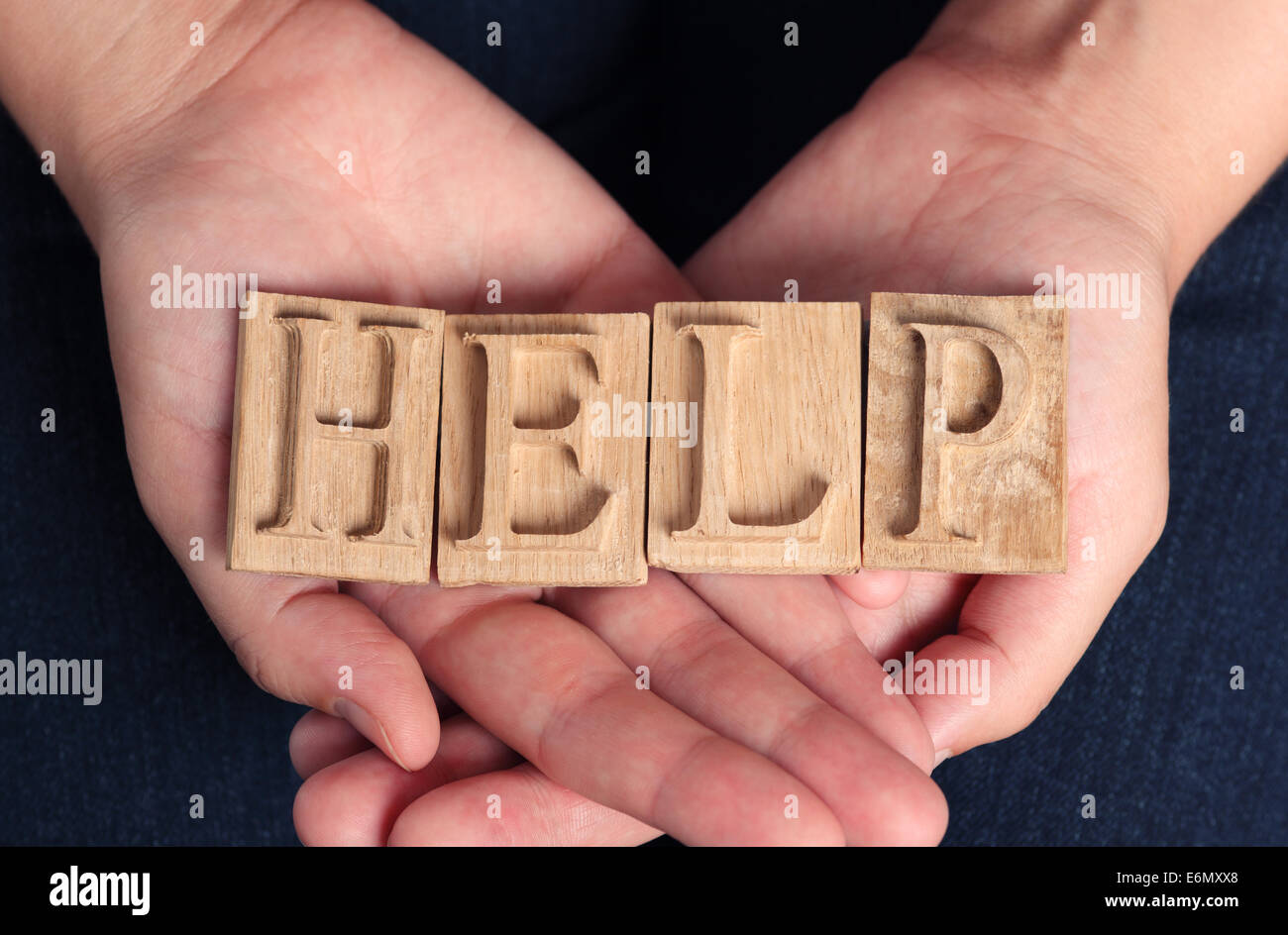 Word "Help" spelled out in letterpress letters in the woman's hands ...
