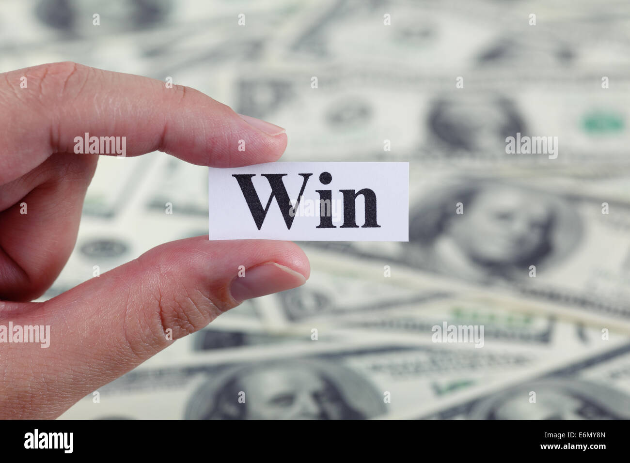 Woman's hand holding a piece of paper with the word "Win" against ...