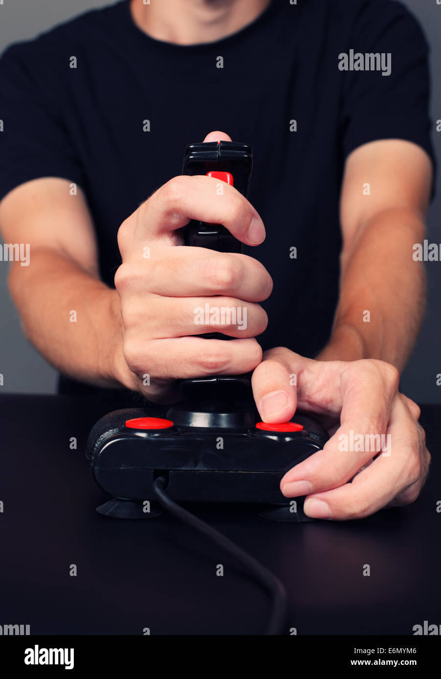 Young man plays video game with a retro joystick. Gaming joystick from ...