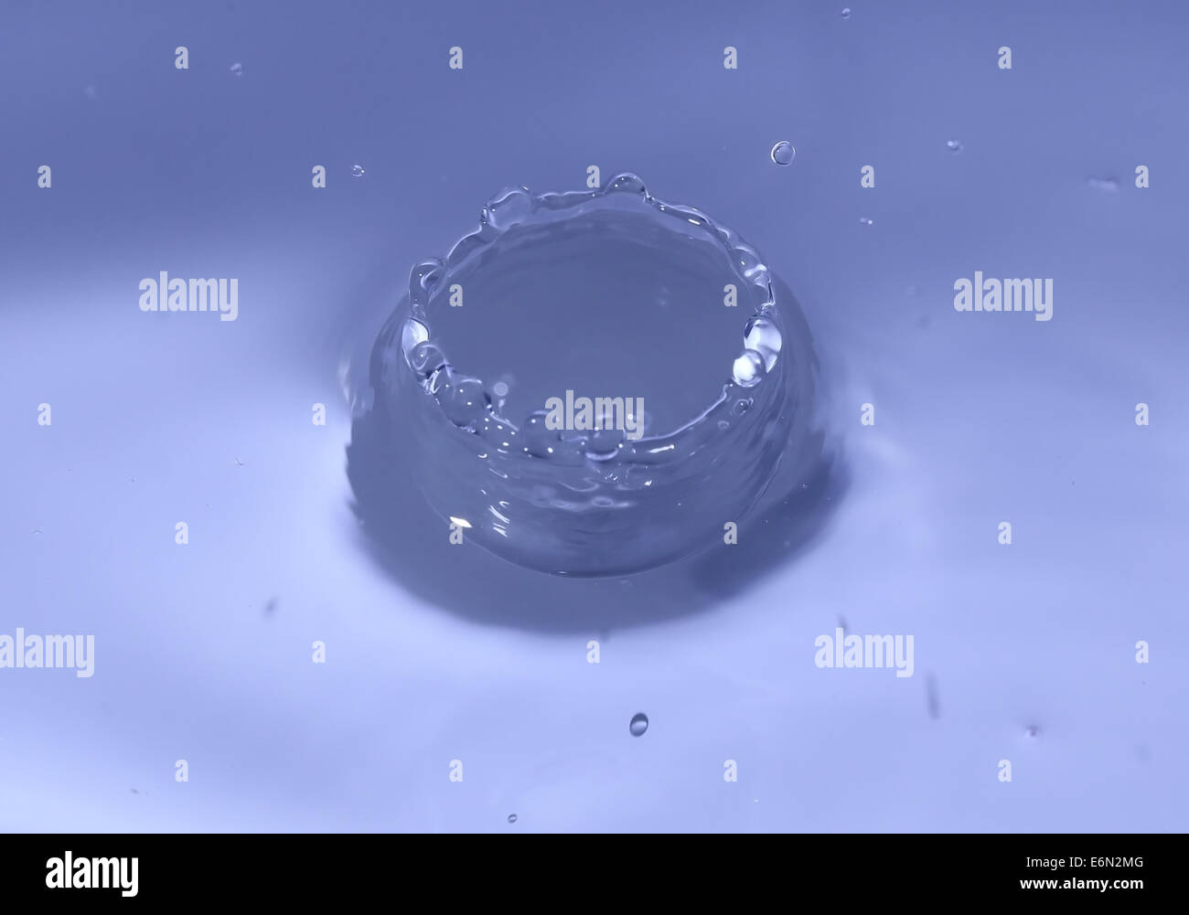 Water splash with a drop of water flying from above Stock Photo - Alamy