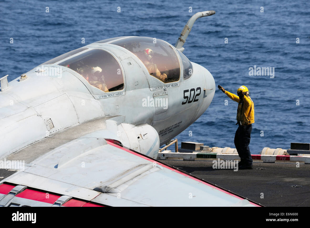 US Navy sailor directs an EA-6B Prowler aircraft on the flight deck of ...