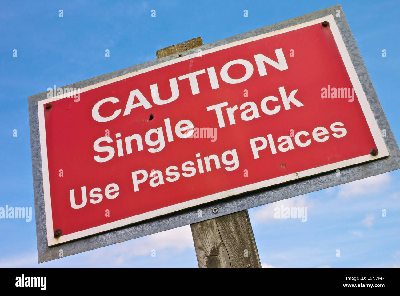Red sign against blue sky background. Caution Single Track - Use ...