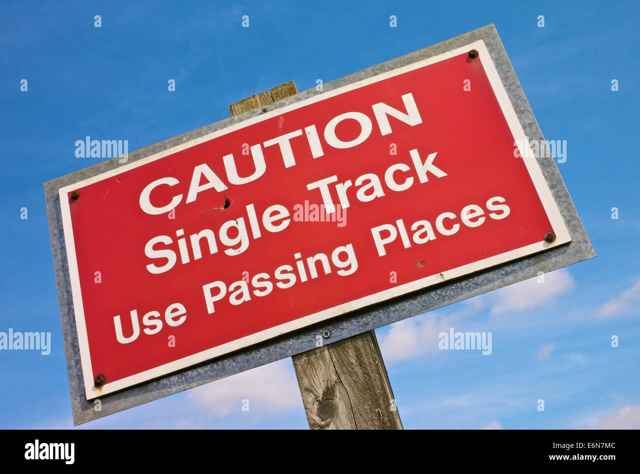 Red sign against blue sky background. Caution Single Track - Use ...