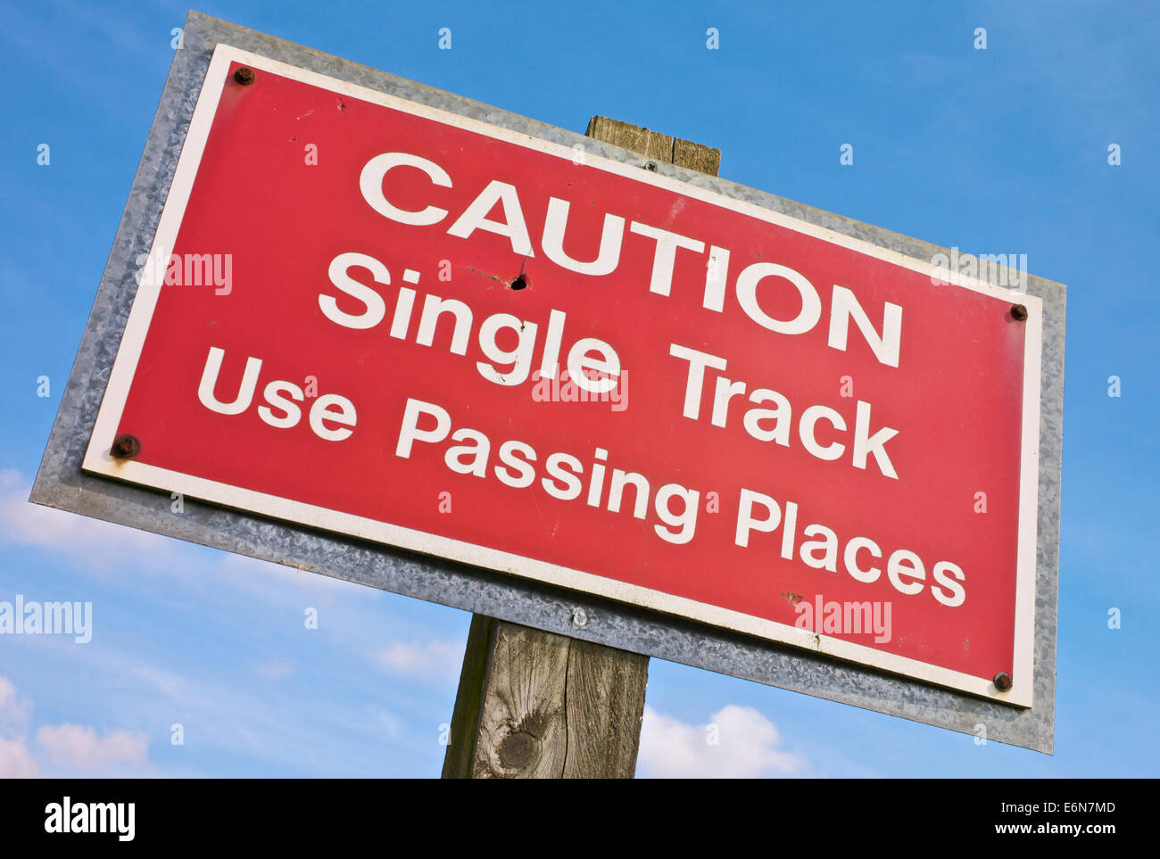 Red sign against blue sky background. Caution Single Track - Use ...