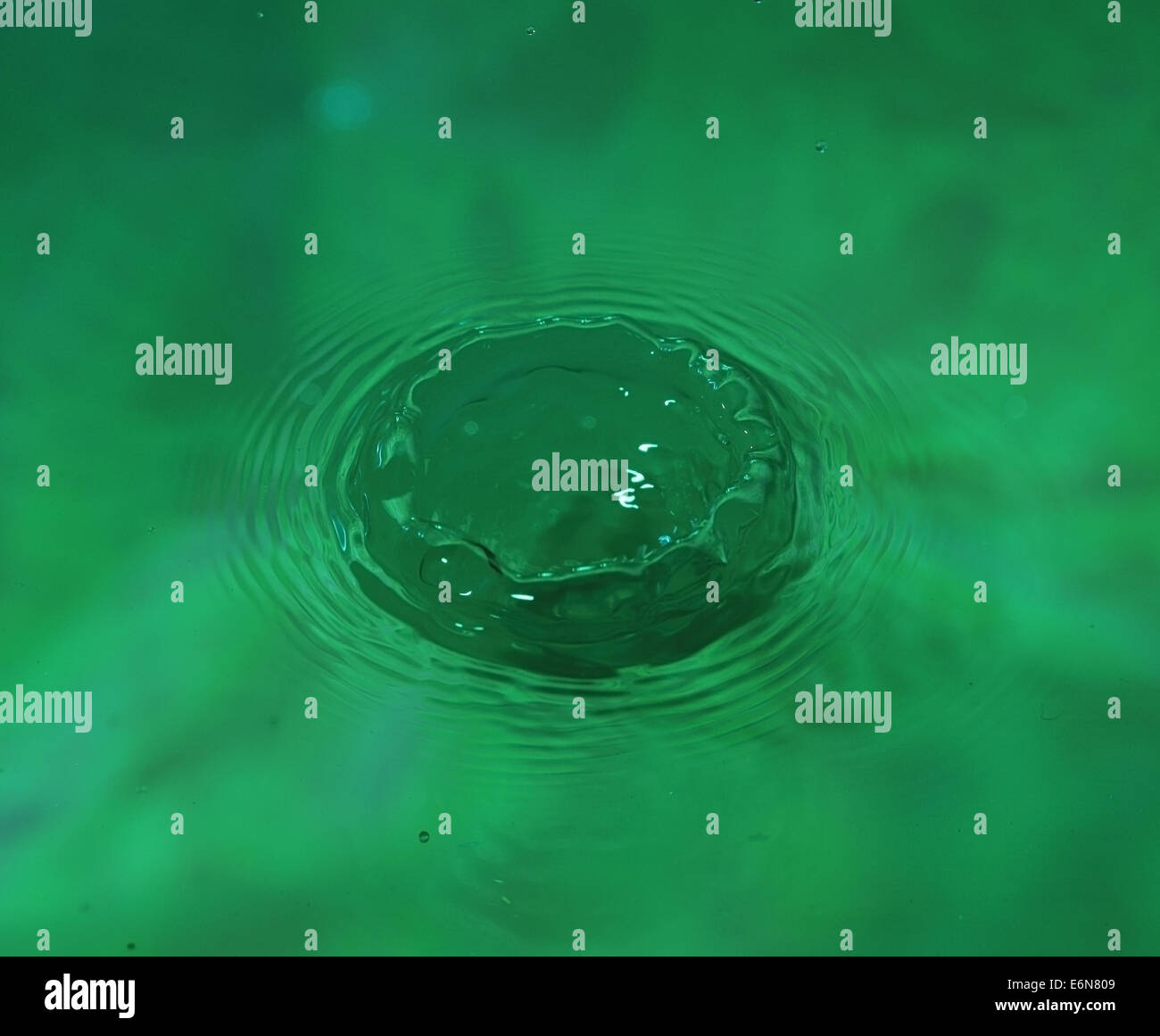 Water splash with a drop of water flying from above Stock Photo - Alamy