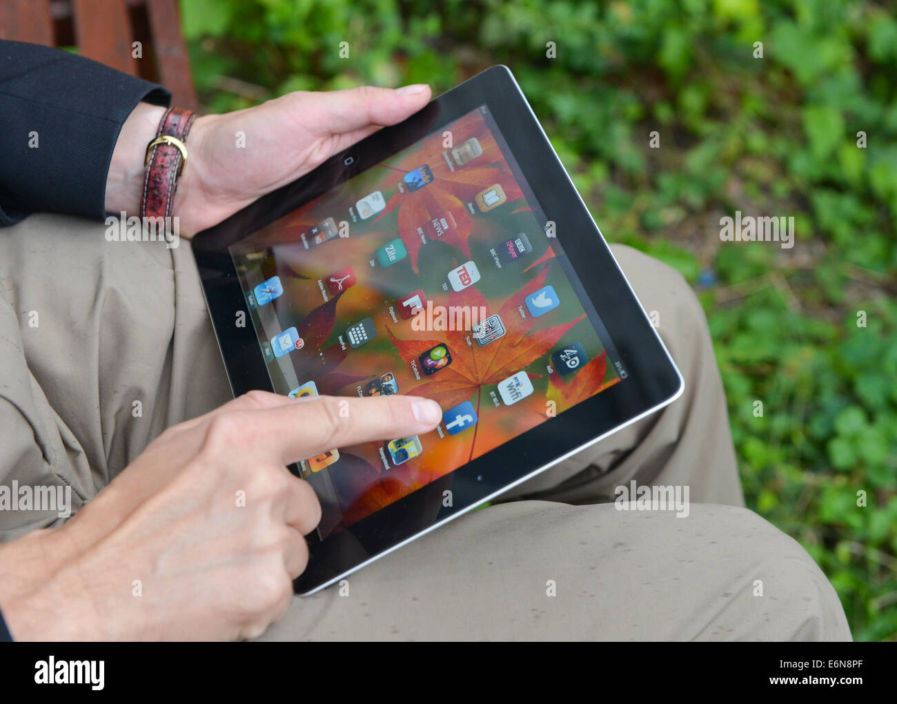 man hands using Apple iPad tablet computer outside Stock Photo - Alamy