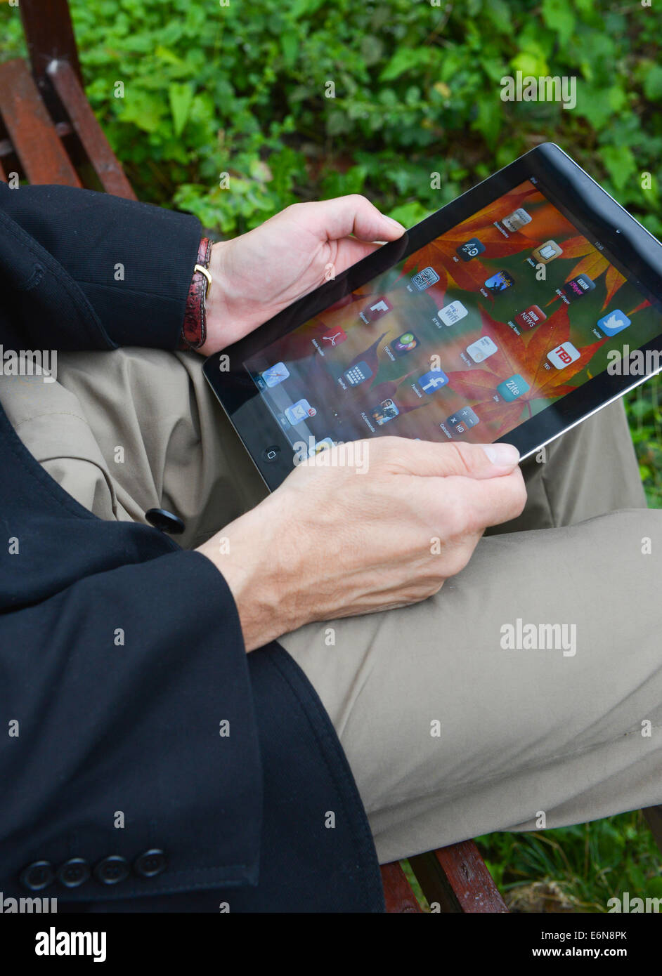 man hands using Apple iPad tablet computer outside Stock Photo - Alamy