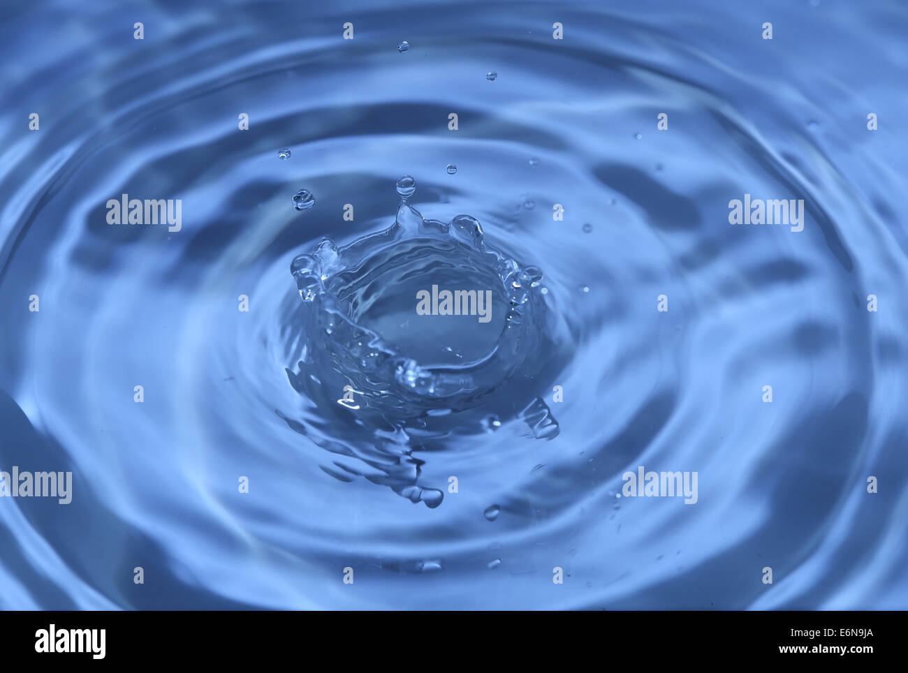 Water splash with a drop of water flying from above Stock Photo - Alamy