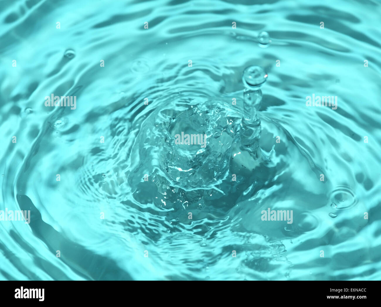 Water splash with a drop of water flying from above Stock Photo - Alamy
