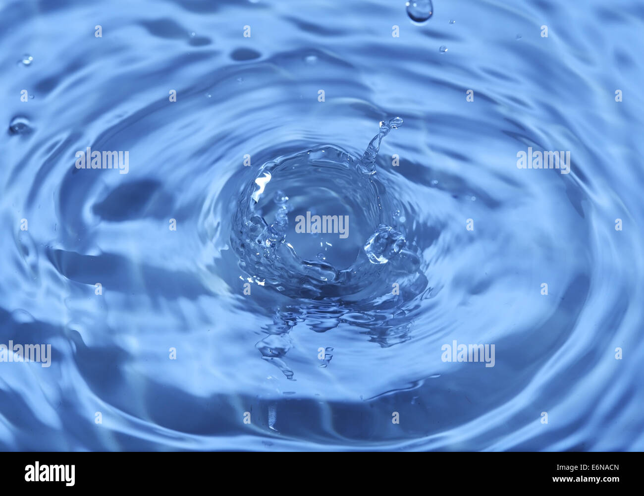 Water splash with a drop of water flying from above Stock Photo - Alamy