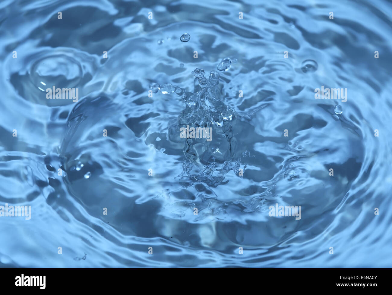 Water splash with a drop of water flying from above Stock Photo - Alamy