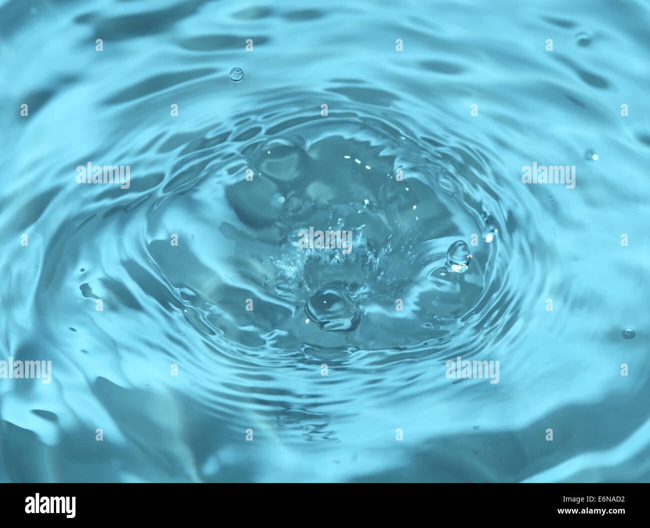 Water splash with a drop of water flying from above Stock Photo - Alamy