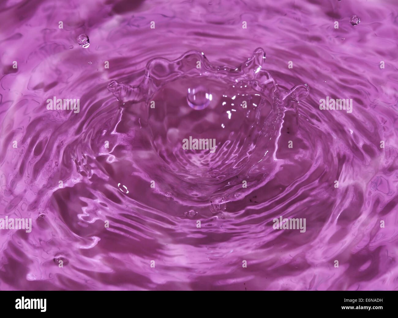 Water splash with a drop of water flying from above Stock Photo - Alamy
