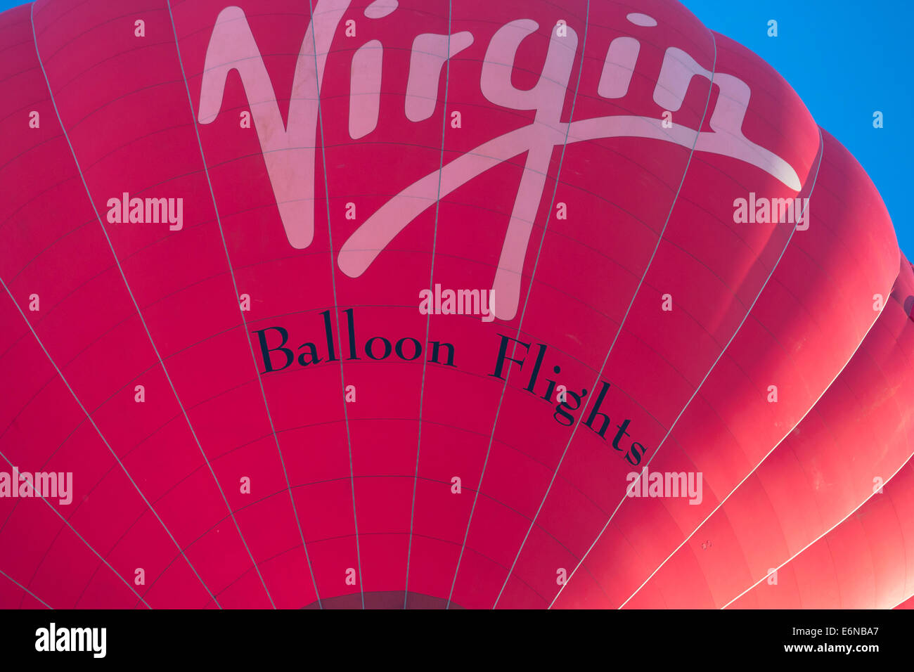 Red Virgin hot air balloon flight with a deep blue late evening sky in ...