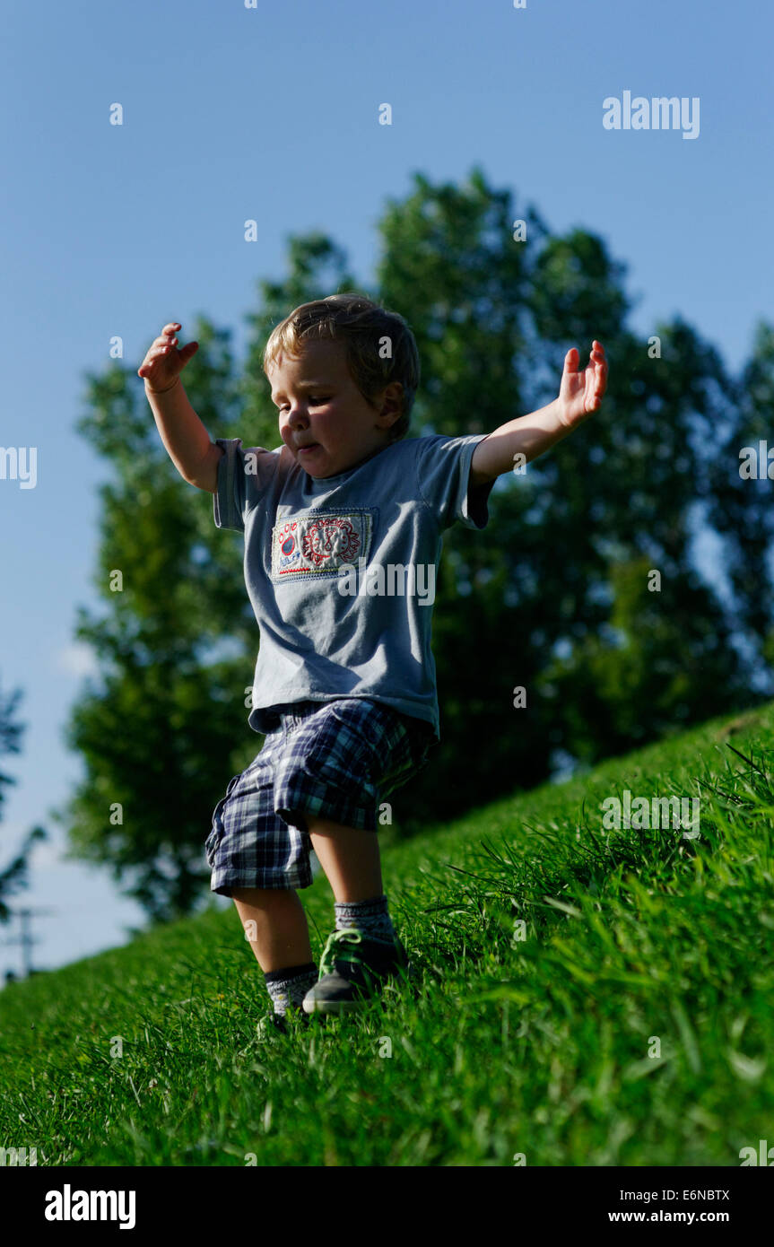 A young boy running down a grassy slope Stock Photo - Alamy