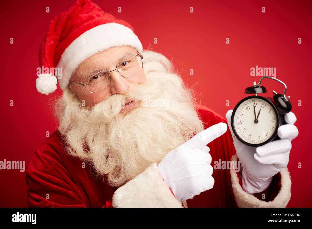 Santa pointing at clock showing five minutes to midnight Stock Photo ...