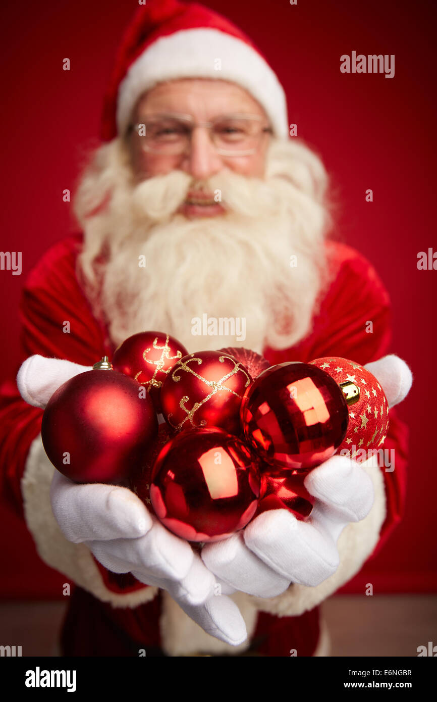 Santa holding red decorative toy balls on his palms Stock Photo - Alamy