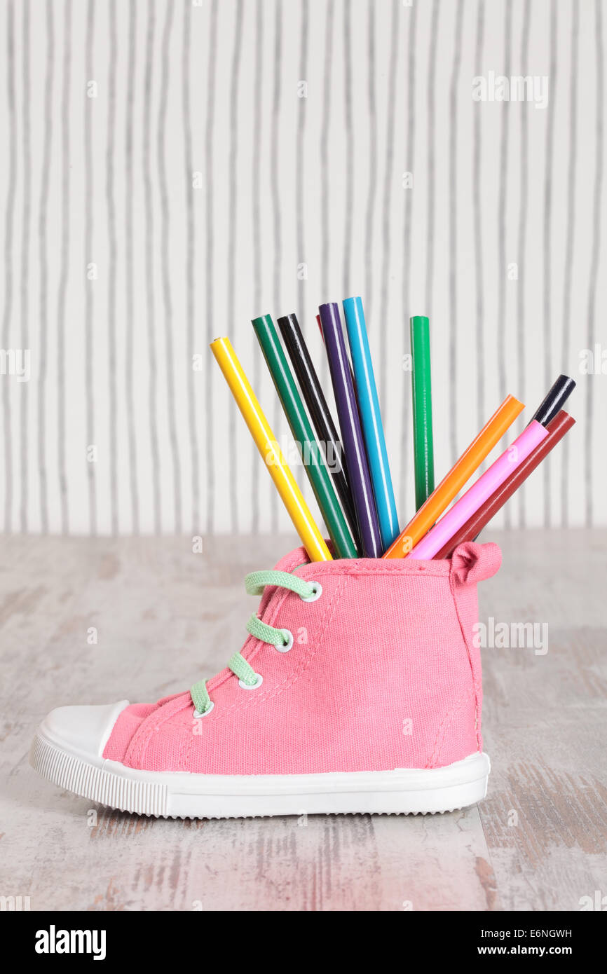 child shoe with colored pencils on a striped background Stock Photo - Alamy