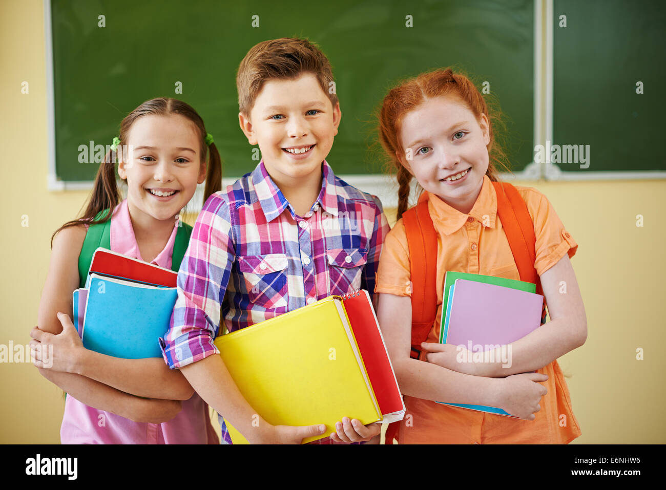 Small group of school friends looking at camera on background of ...