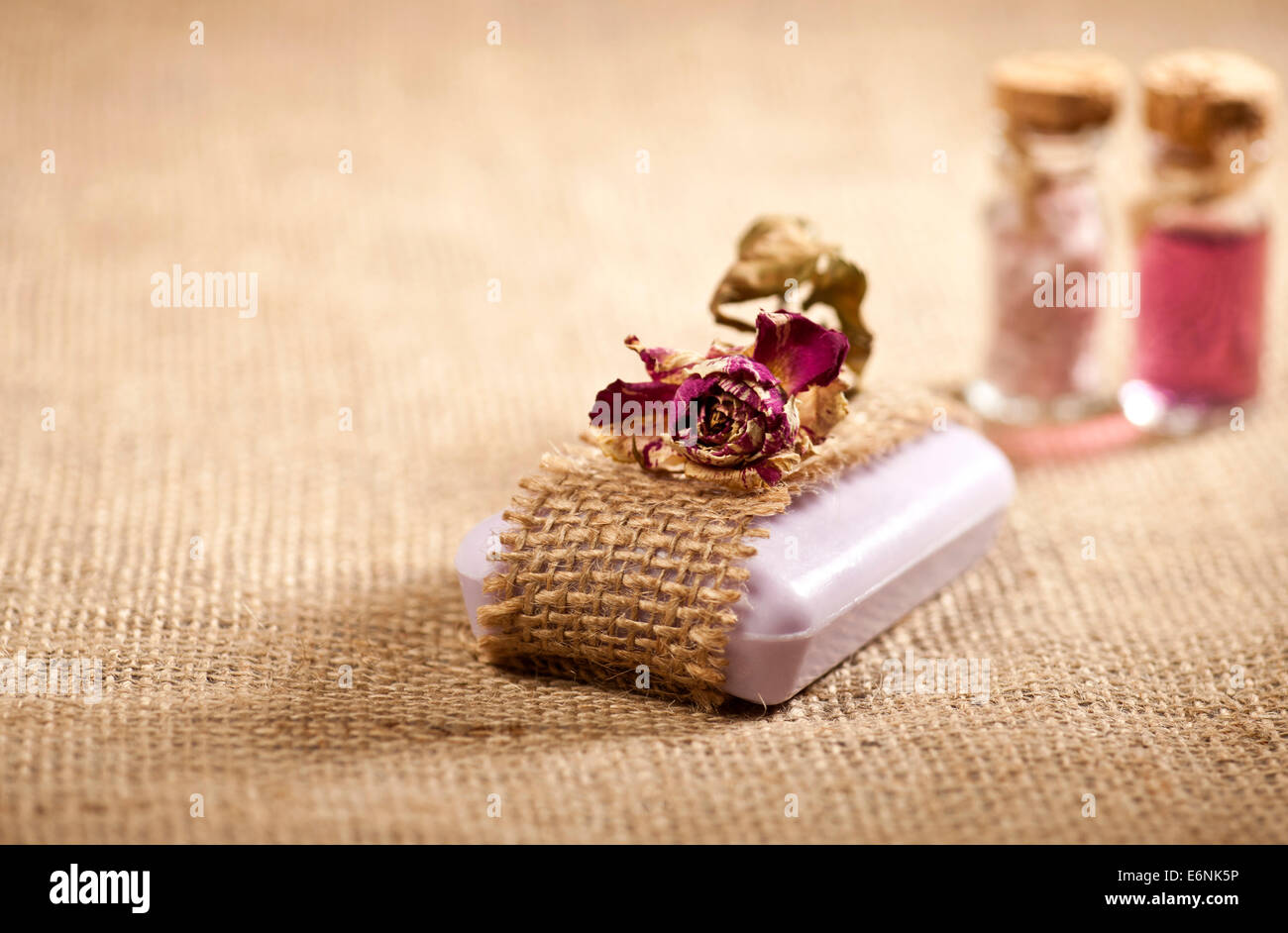 Spa background with purple soap, dried rose and glass bottles with sea ...
