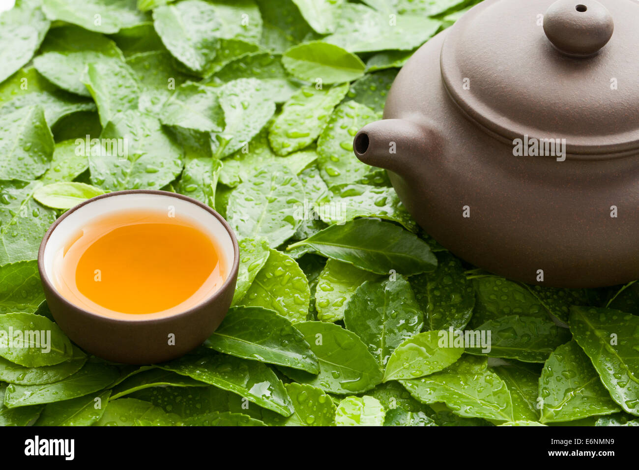 Teapot and cup of tea on green leaves Stock Photo - Alamy