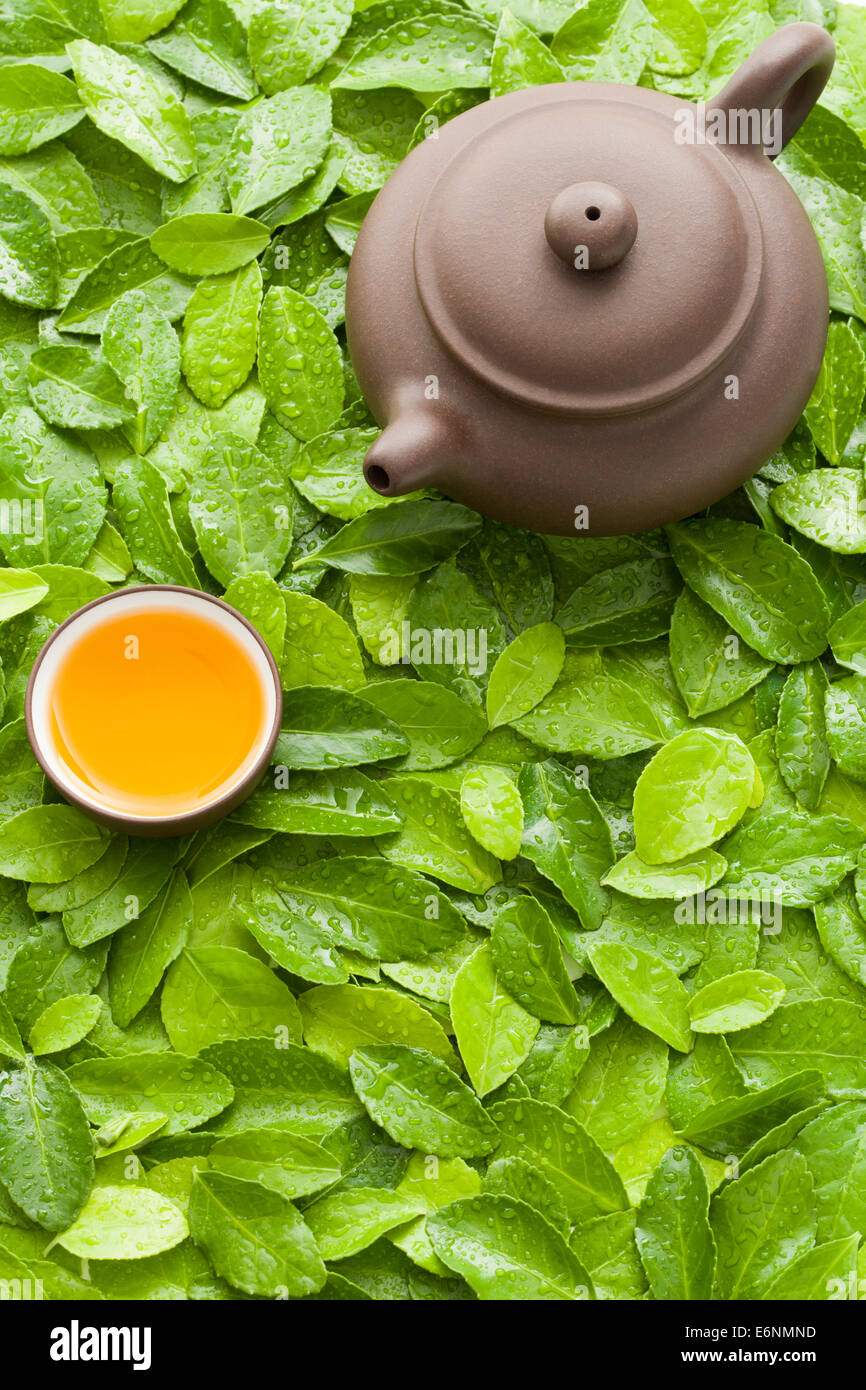 Teapot and cup of tea on green leaves Stock Photo - Alamy