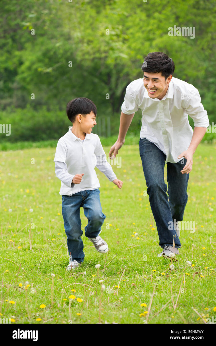Happy father and son running on the grass Stock Photo - Alamy