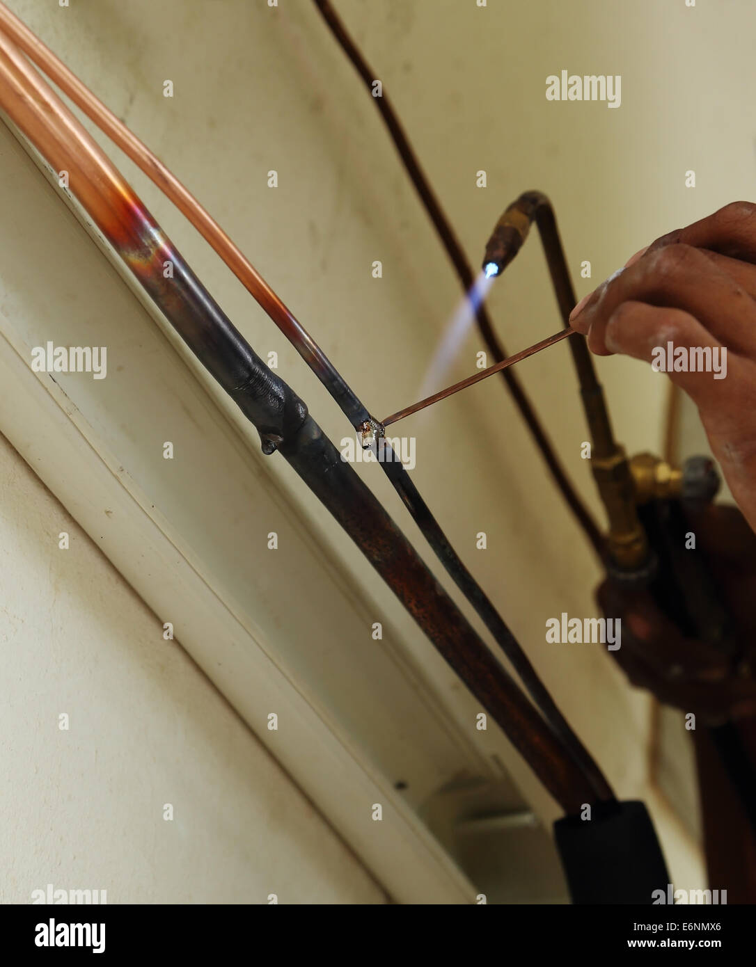 Air conditioner repairman welding copper pipes Stock Photo - Alamy