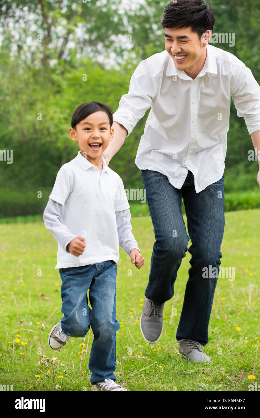 Happy father and son running on the grass Stock Photo - Alamy