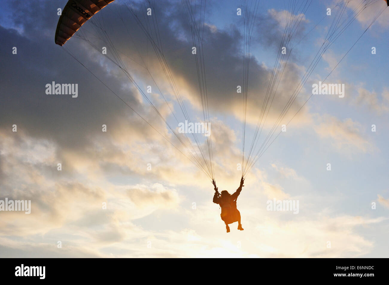 Paraglider flying at sunset Stock Photo - Alamy