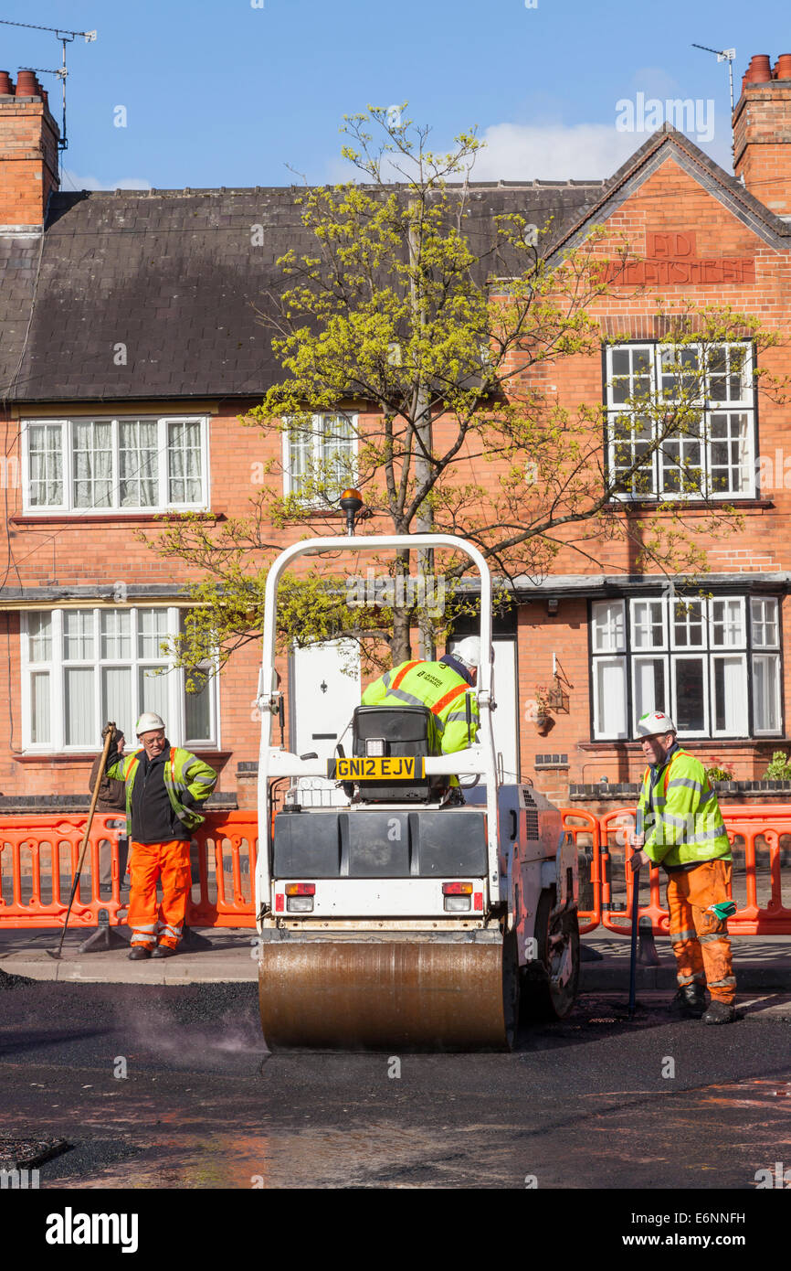 Road repairs. Road roller being used during road resurfacing work ...