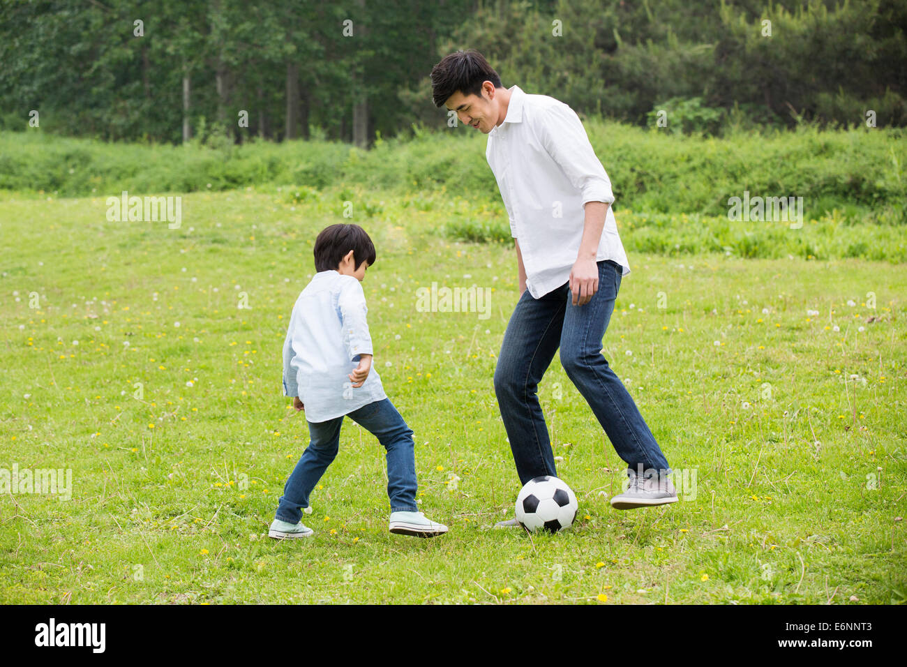 Happy father and son playing football together Stock Photo - Alamy