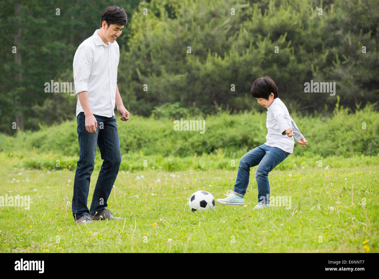 Happy father and son playing football together Stock Photo - Alamy