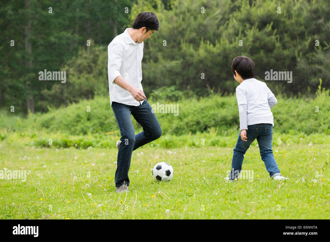 Happy father and son playing football together Stock Photo - Alamy