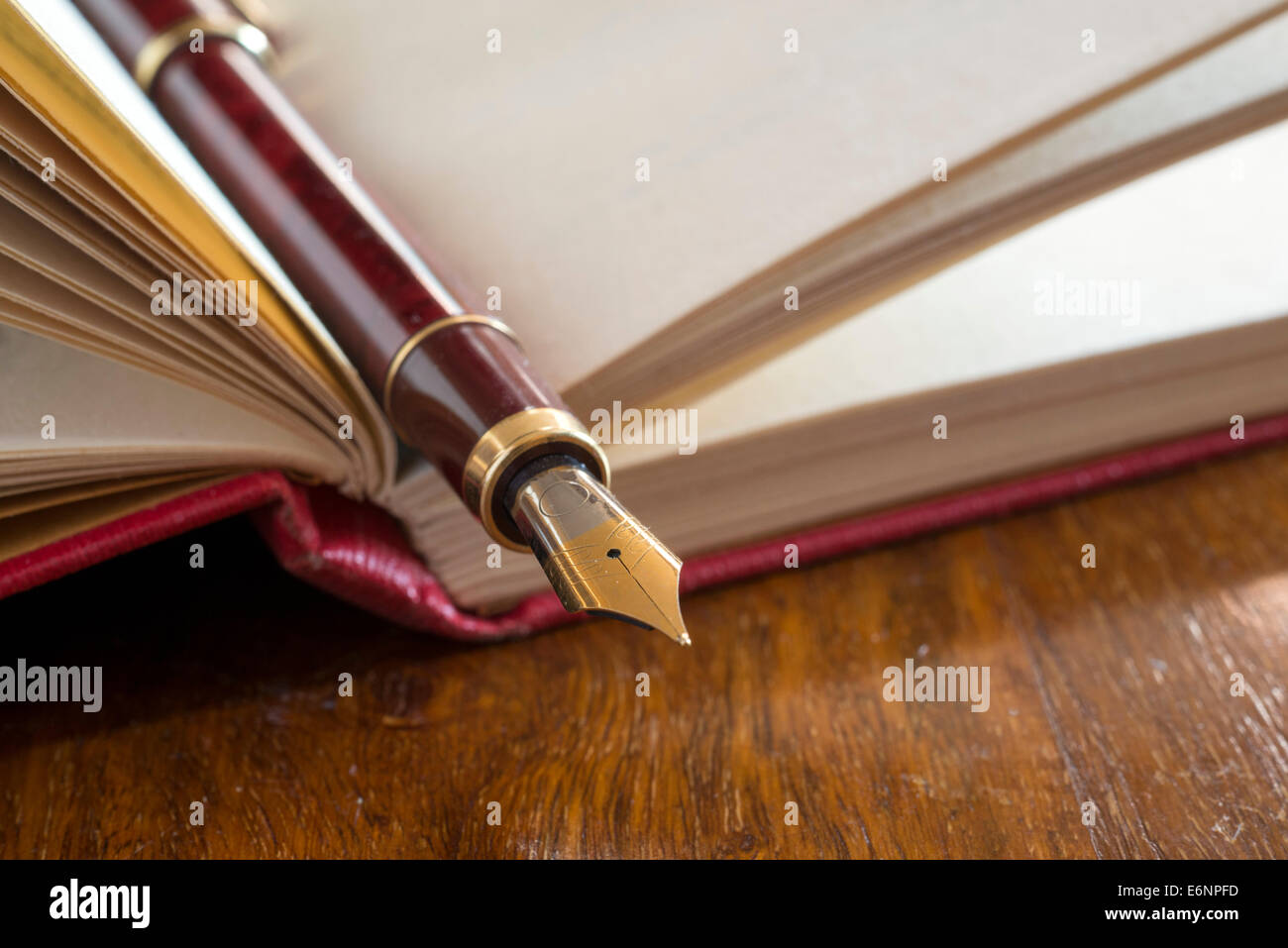 Closeup of fountain pen on a red book on a wooden table Stock Photo - Alamy