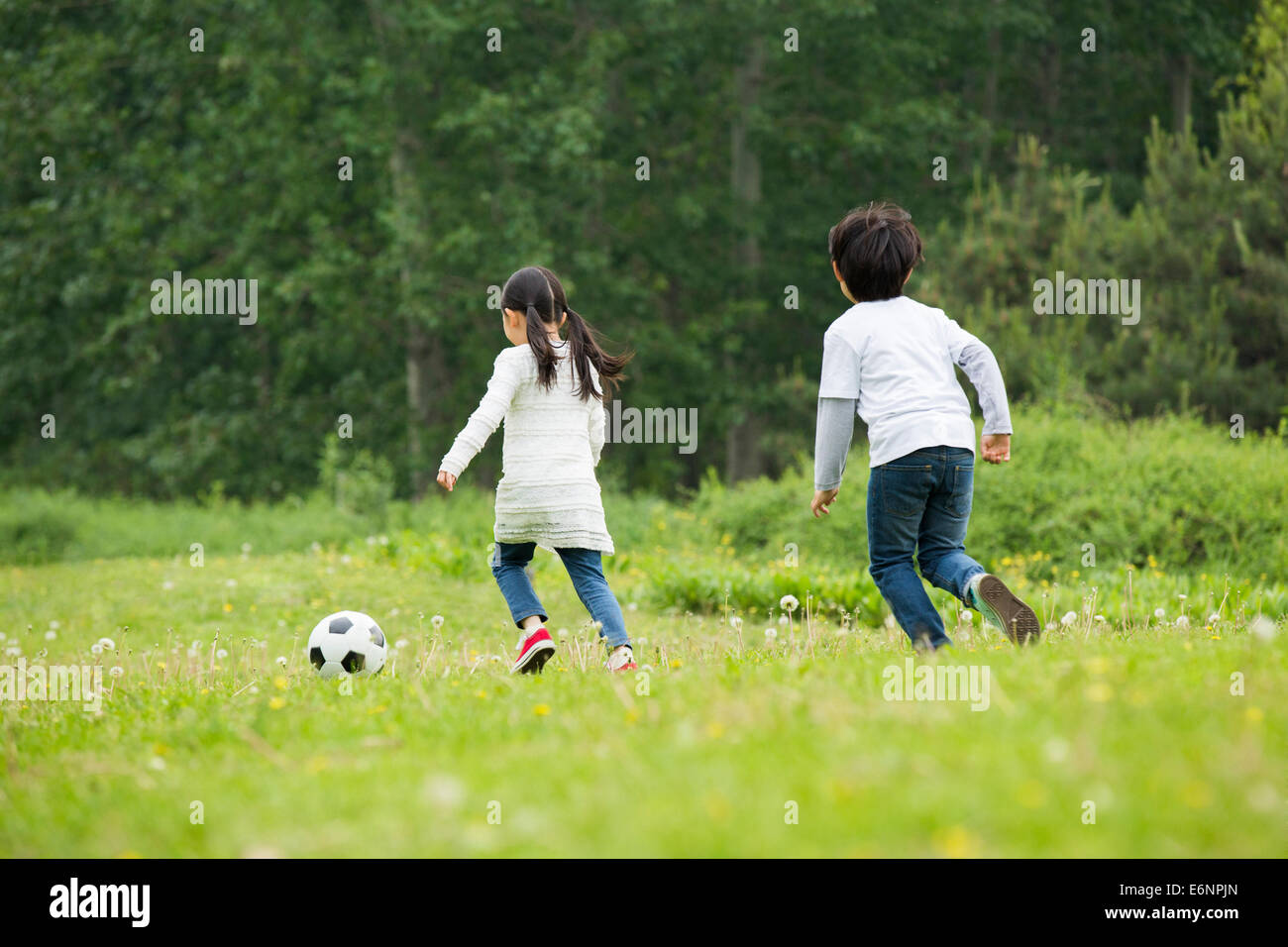 Happy children playing football together Stock Photo - Alamy