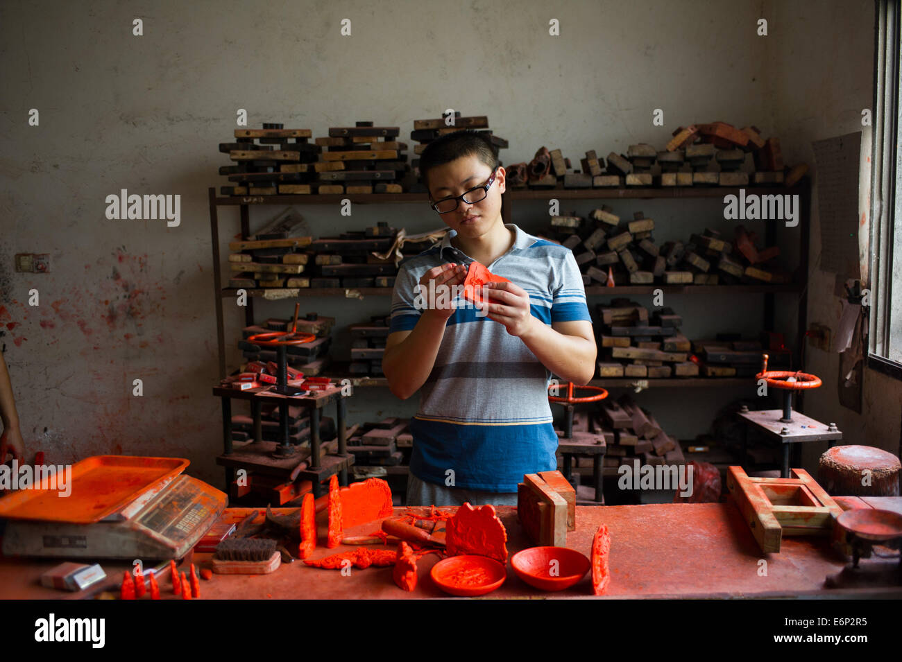 Shexian, China. 28th Aug, 2014. Xiang Song adjusts the shape of an ...
