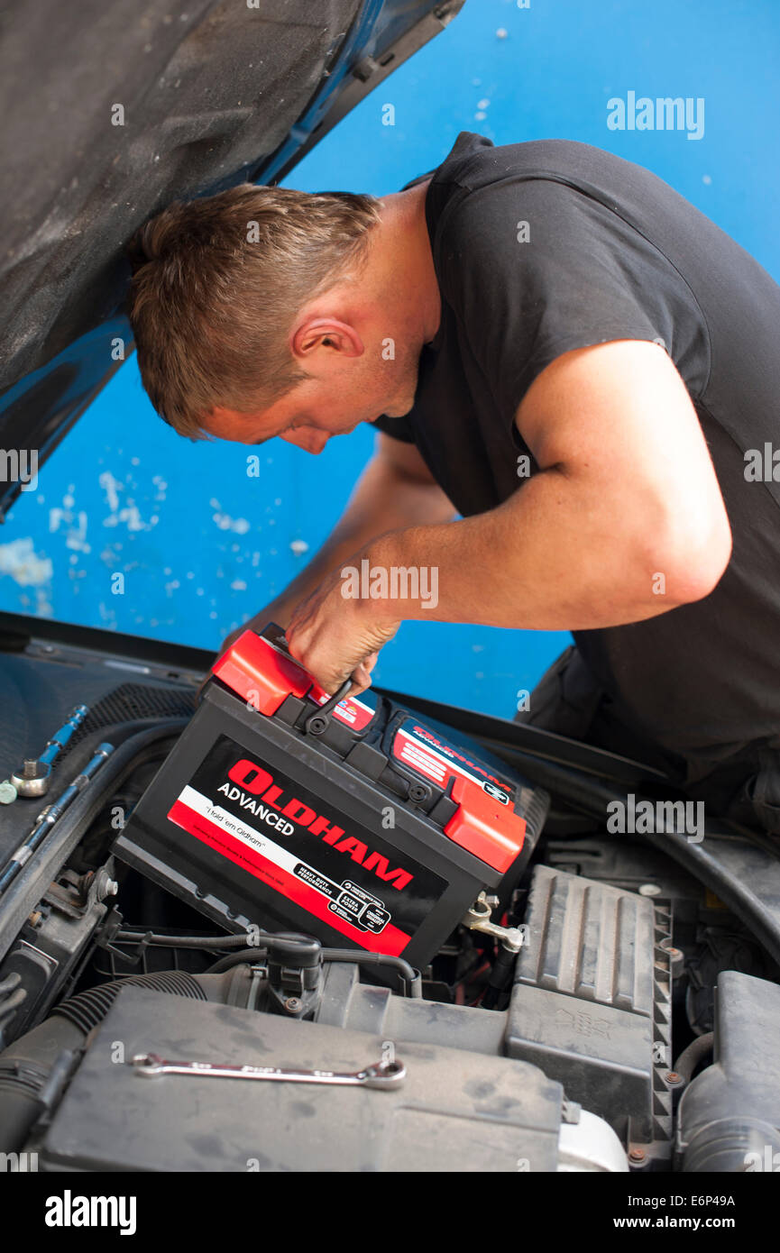 car mechanic replacing an old battery with new Stock Photo - Alamy