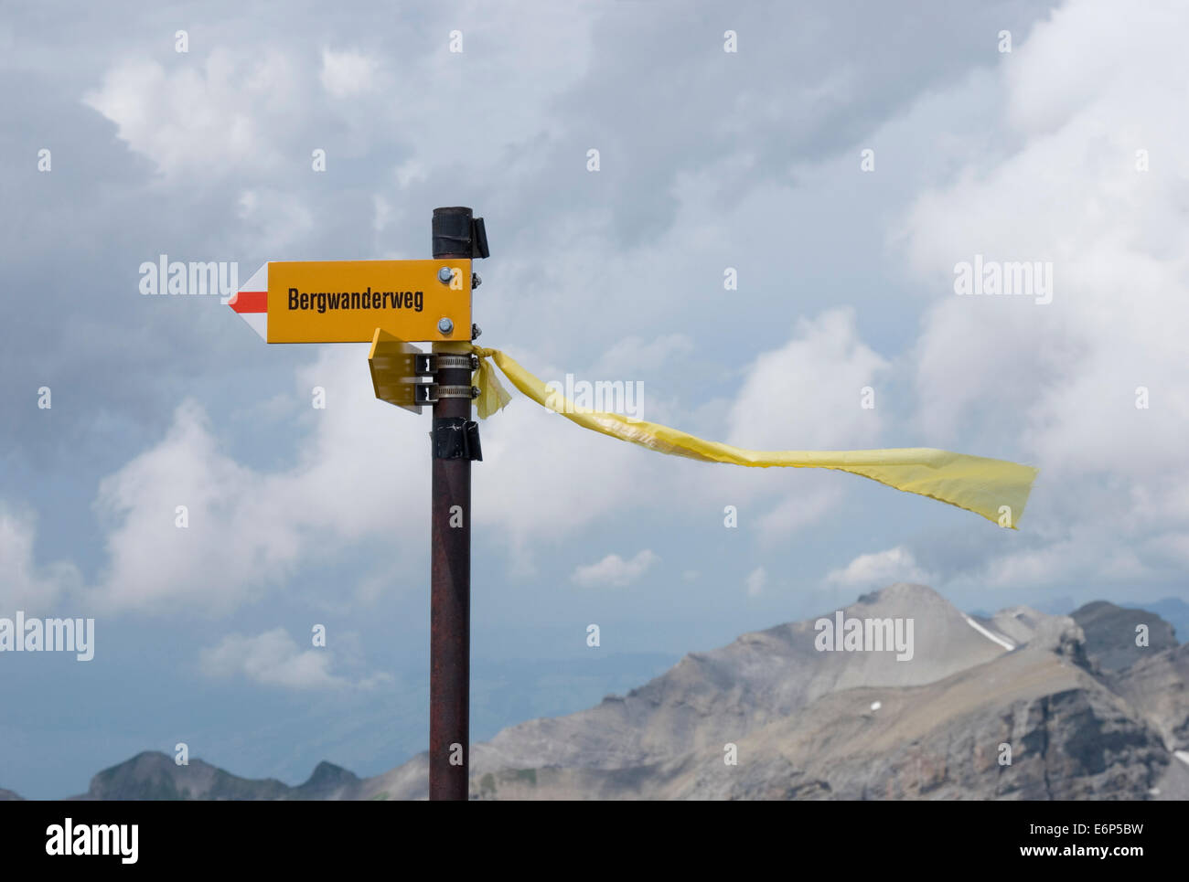 Trail sign with yellow ribbon in the Swiss Alps, Oberland, Switzerland ...