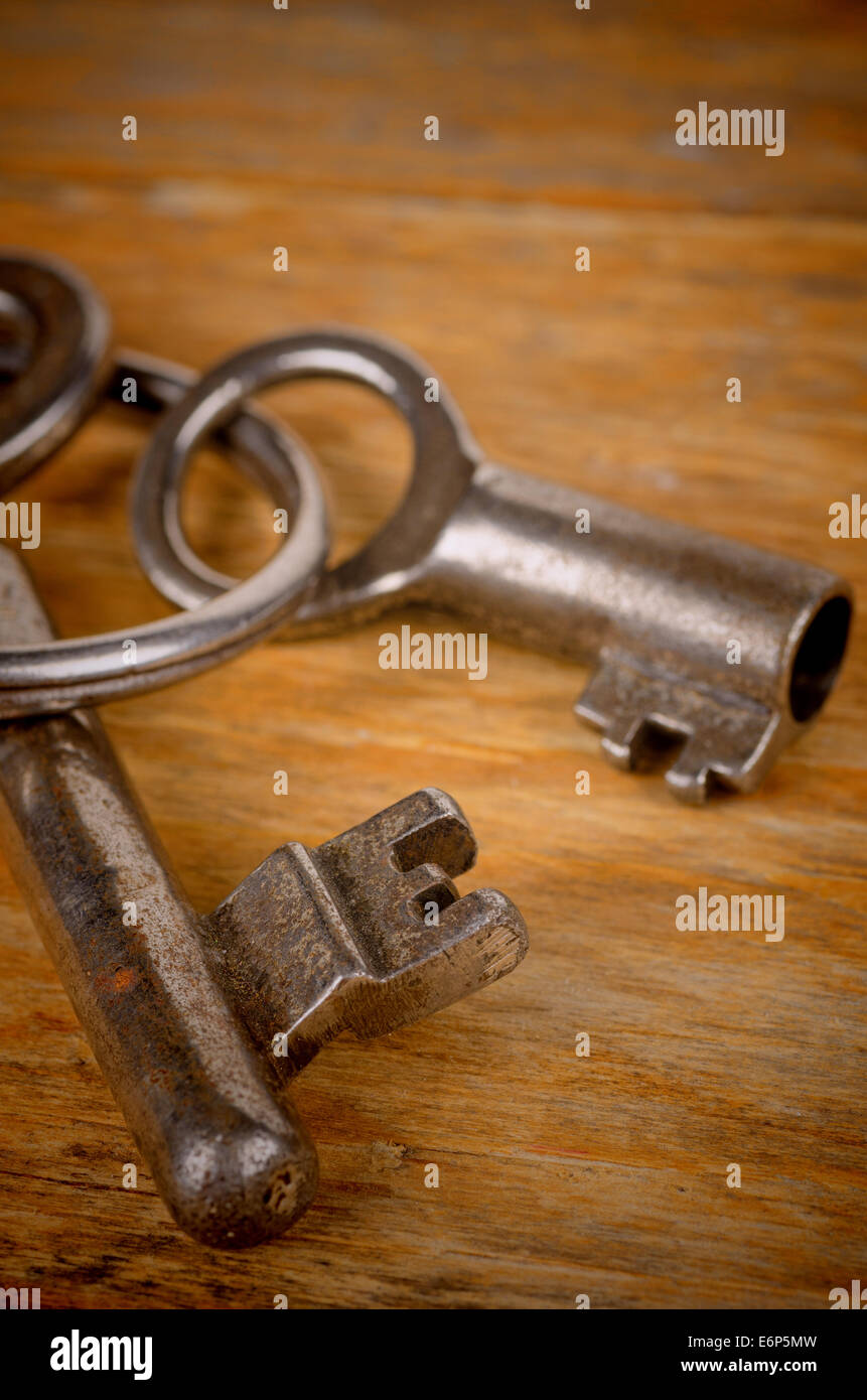 Old keys and key ring on a wooden background Stock Photo - Alamy