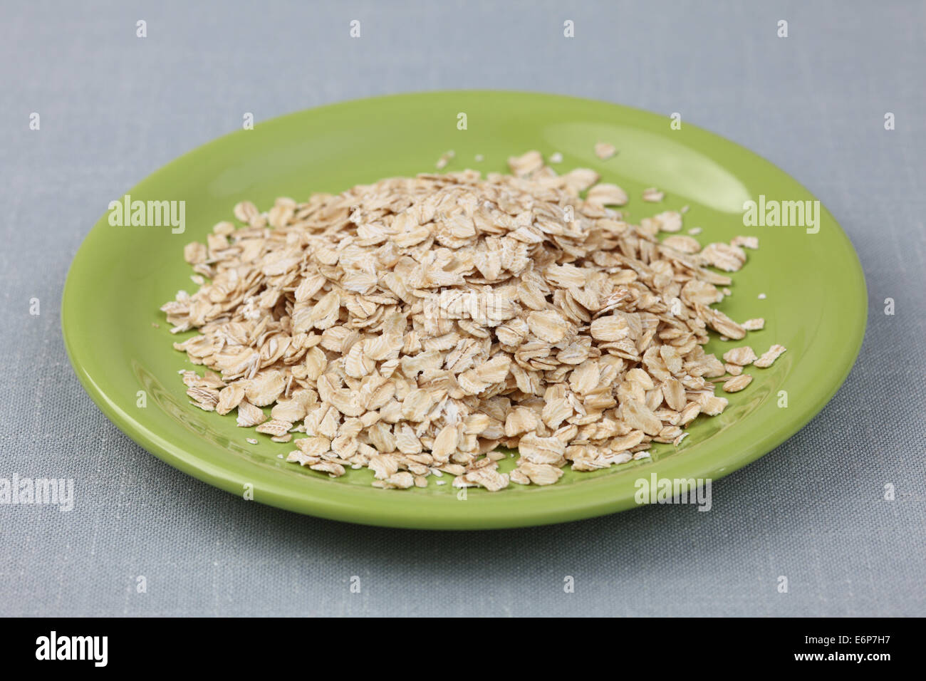 Rolled oats (oat flakes) on a green plate Stock Photo - Alamy