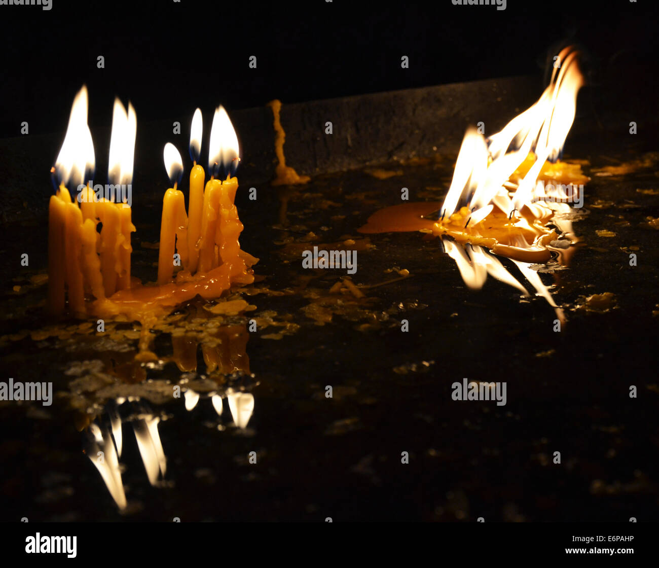 Burning candles in a church on a dark background Stock Photo - Alamy