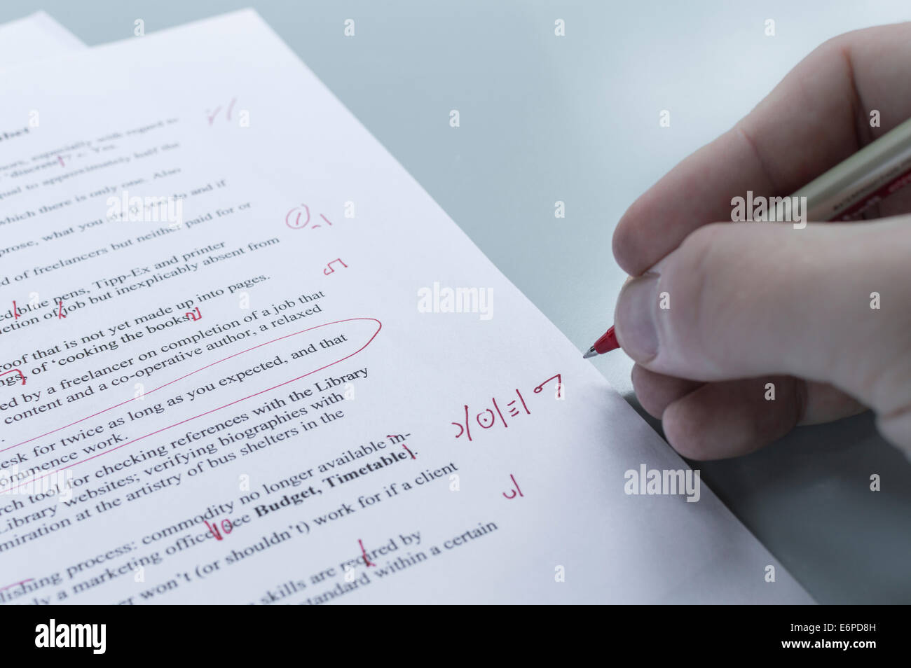 The hand of a proofreader makes hand-written corrections to a printed ...