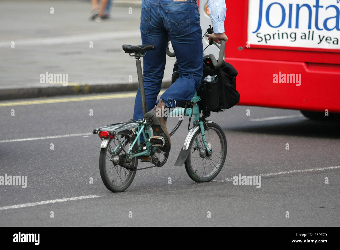A cyclist and bus traveling along a road in London Stock Photo - Alamy