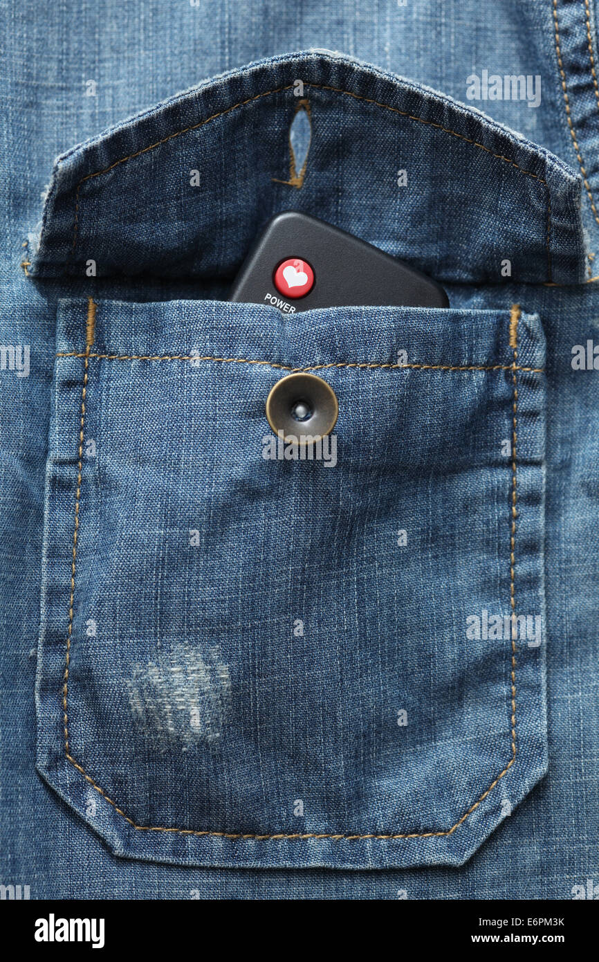 Remote control with a heart symbol on the red button in the denim shirt ...