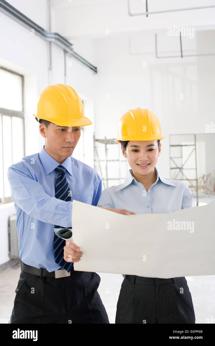 Two colleagues discussing a blueprint Stock Photo - Alamy
