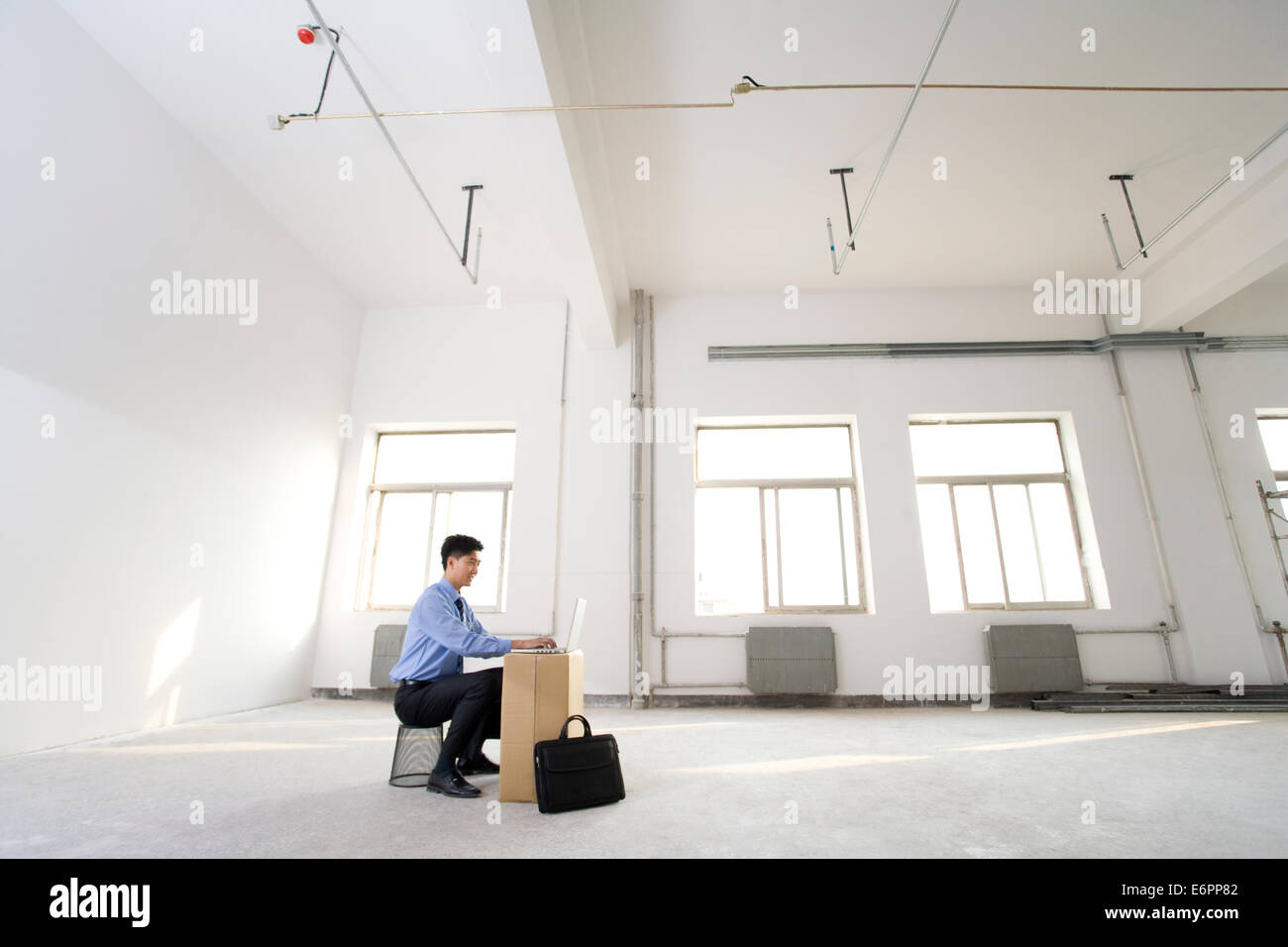 Businessman working in an empty office space Stock Photo - Alamy