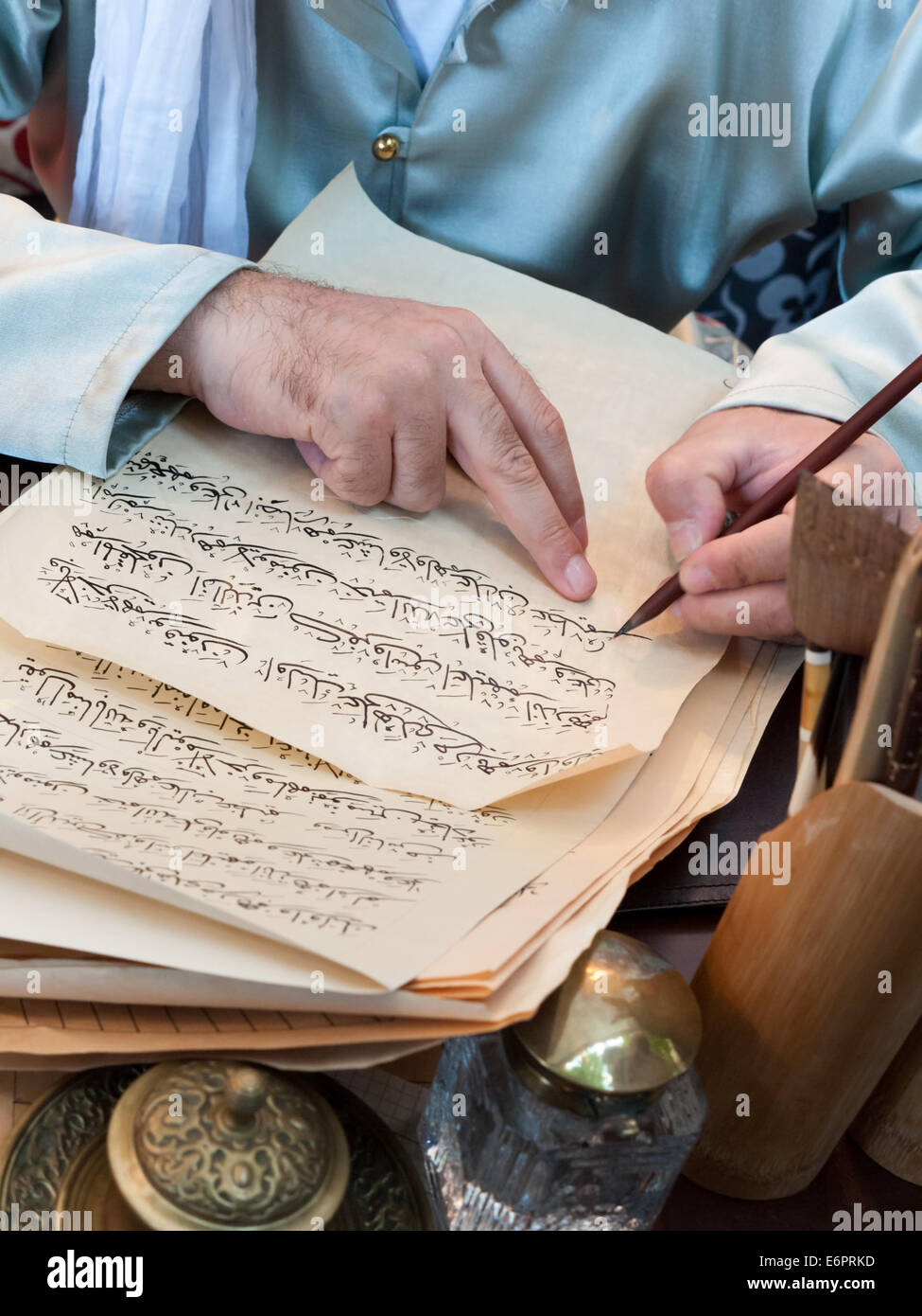 Male hands writing traditional Arabian calligraphy Stock Photo - Alamy