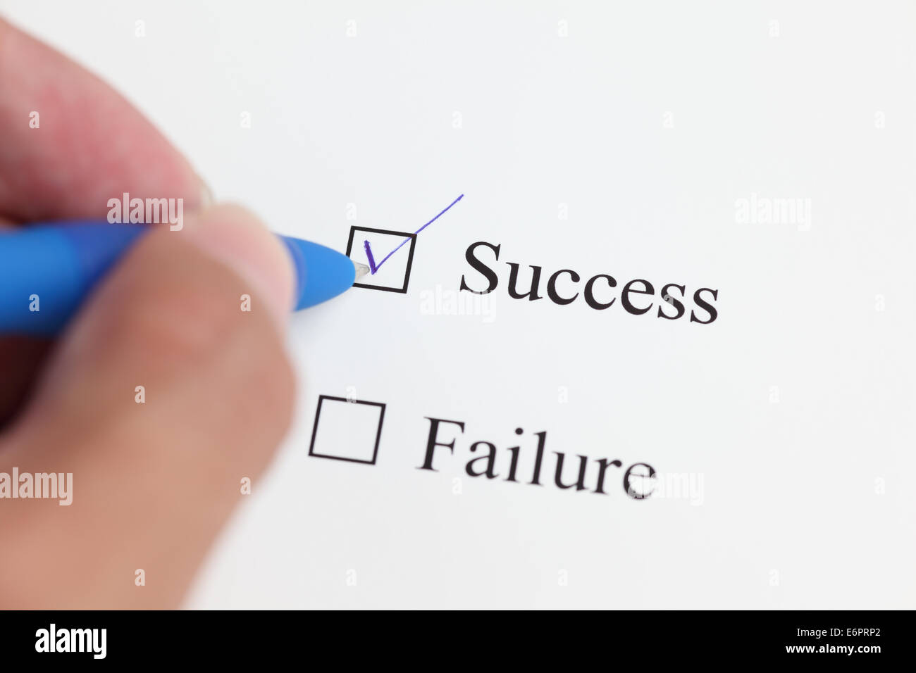 Hand with ballpoint pen marking the "SUCCESS" checkbox on a document ...