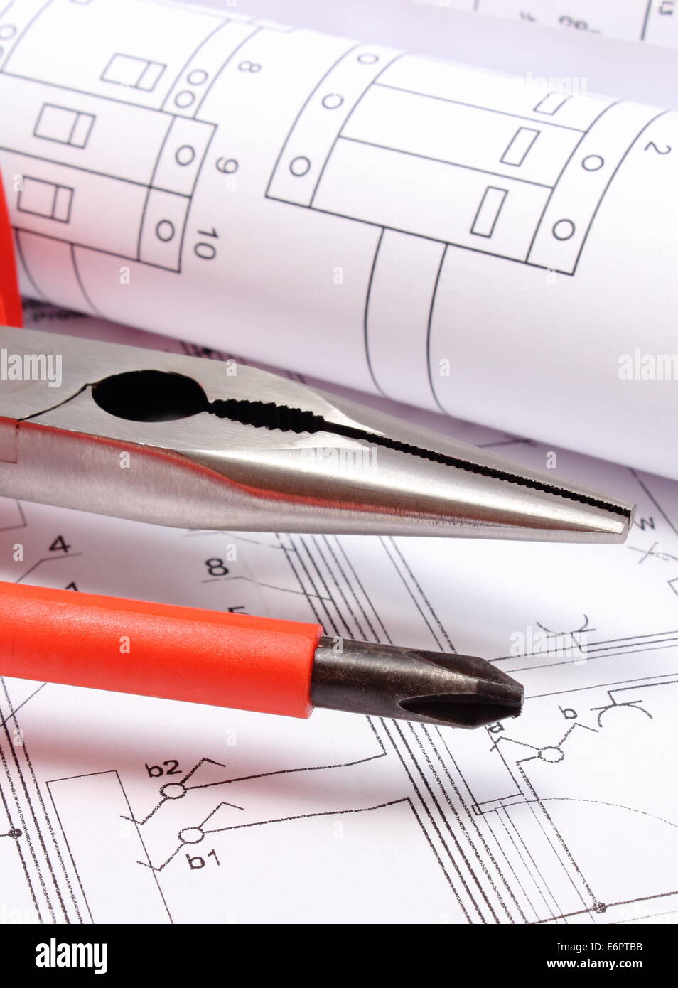 Rolled electrical diagrams with work tools lying on construction ...